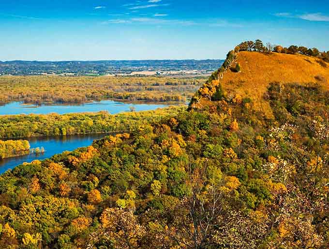 Nature's masterpiece on display: Great River Bluffs State Park showcases autumn's fiery palette against the mighty Mississippi, a scene worth every mile of the journey.