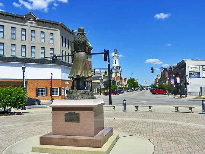 Greenville's downtown square welcomes visitors with its iconic statue standing sentinel against a backdrop of historic architecture and blue Ohio skies.