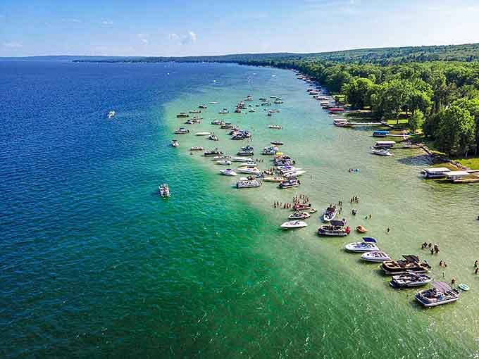 Aerial paradise: Hubbard Lake's crystal waters create a Caribbean-like oasis in Michigan's heartland, where boats gather in nature's perfect swimming pool.