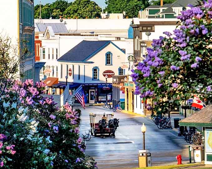 Mackinac Island's Main Street welcomes visitors with Victorian charm and horse-drawn carriages instead of honking taxis and traffic jams.
