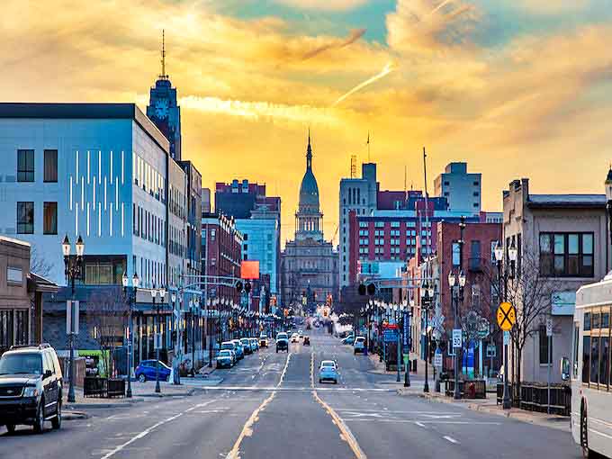Michigan Avenue stretches toward the Capitol like a welcoming runway, the golden dome glowing against twilight skies that seem painted just for visitors.