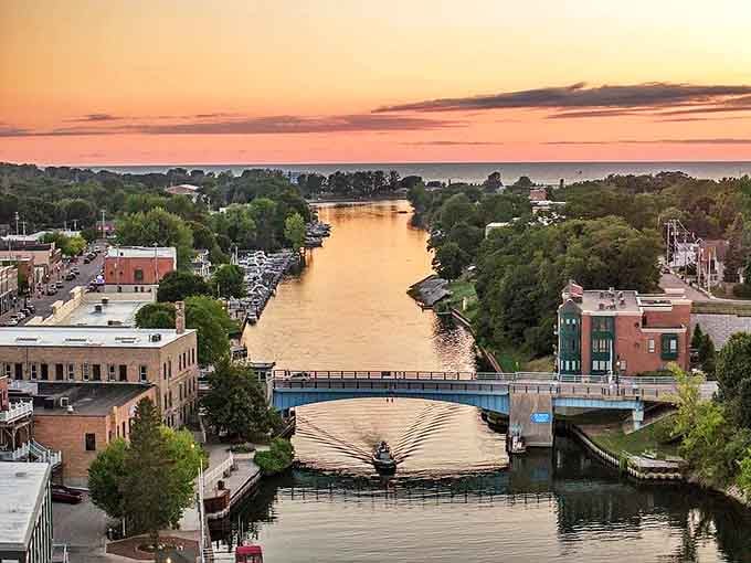 Sunset paints Manistee's riverfront in golden hues, where Victorian architecture meets modern leisure along Michigan's hidden coastal treasure.