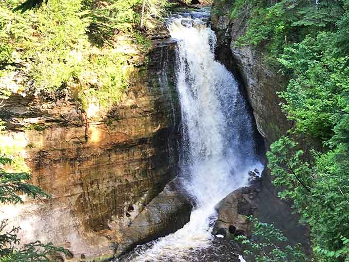 Forty feet of pure Michigan magic cascading over ancient sandstone, because apparently Mother Nature decided the Upper Peninsula needed a showstopper.
