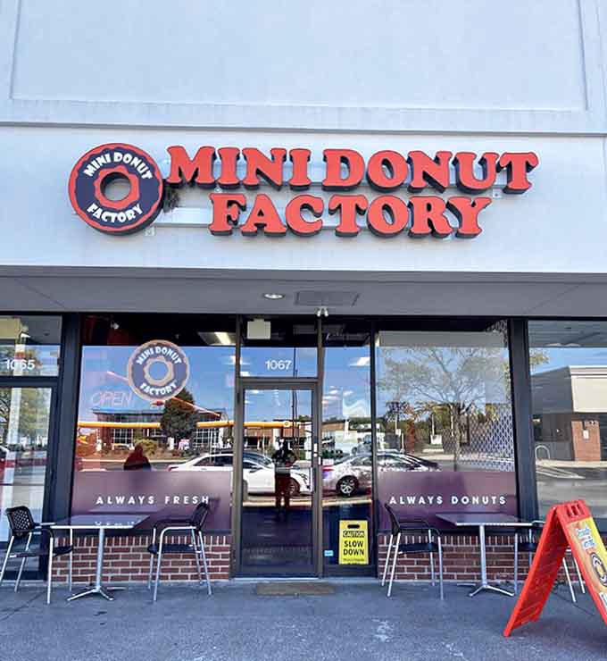 The bright red signage of Mini Donut Factory beckons from the strip mall, promising tiny circles of joy within.