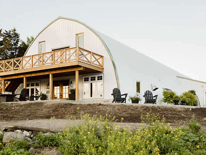The iconic curved roof of Molitor Milk Barn stands proudly against Minnesota's sky, promising rustic luxury and peaceful seclusion.
