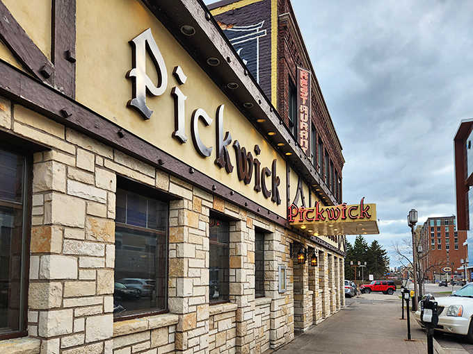 The iconic stone facade of Pickwick Restaurant & Pub glows with welcome, a beacon of culinary tradition on Duluth's Superior Street.