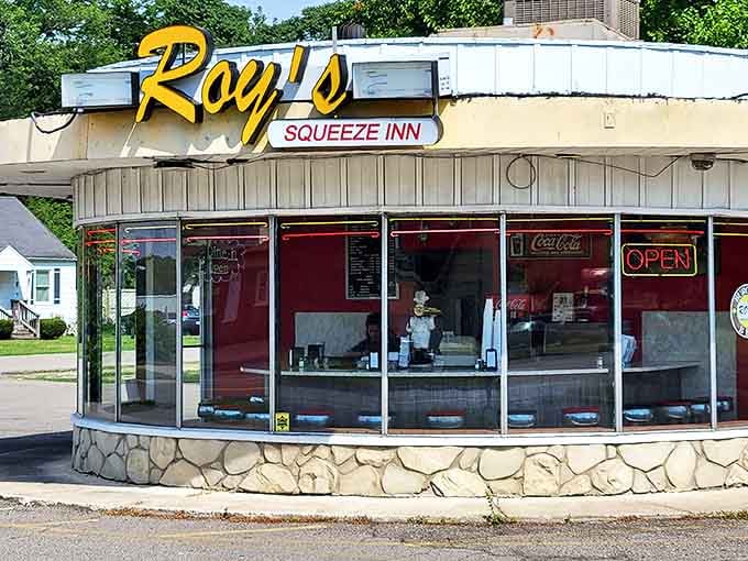 The iconic circular building of Roy's Squeeze Inn glows with nostalgic charm, its vintage sign promising burger bliss to Ypsilanti locals and visitors alike.