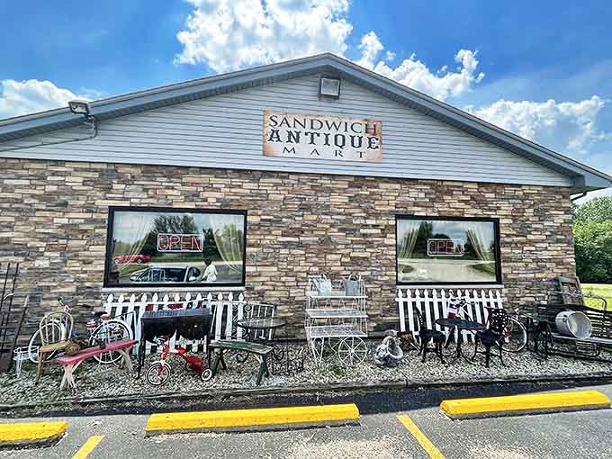 The stone-faced exterior of Sandwich Antique Mart welcomes treasure hunters with vintage tricycles and farm implements – like your grandmother's garage had a growth spurt!