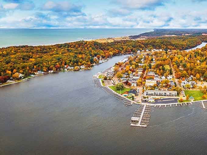 Aerial splendor of Saugatuck where the Kalamazoo River meets Lake Michigan &ndash; nature showing off its perfect marriage of blue waters and autumn-painted shores.