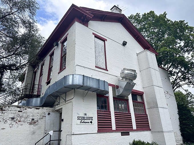 The historic white brick schoolhouse with distinctive red trim stands proudly in Camp Dennison, promising culinary lessons worth learning inside its 1863 walls.