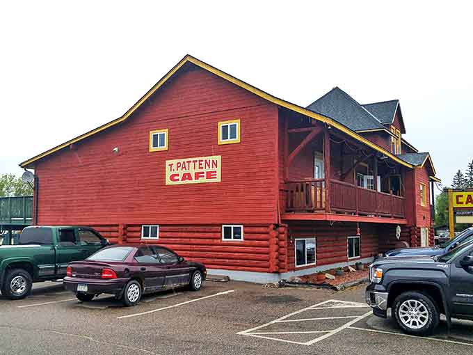 The iconic red log cabin exterior of T Pattenn Cafe stands proudly along Highway 53, beckoning hungry travelers with promises of breakfast served anytime.
