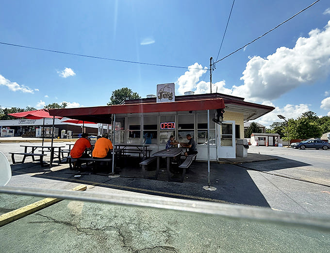The unassuming white building with its vintage sign promises burger perfection without pretense &ndash; a time capsule of American dining at its most authentic.