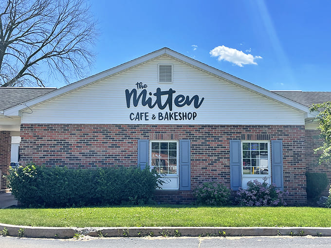The charming exterior of The Mitten Cafe & Bakeshop looks like it belongs on a postcard, complete with blue shutters and a perfectly manicured lawn that says "welcome home."