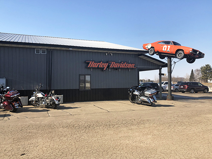 The iconic General Lee Dodge Charger suspended above Doc's entrance &ndash; a sky-high invitation to automotive paradise below.