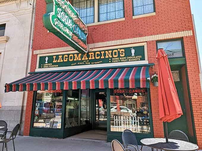The iconic green sign against red brick promises sweet nostalgia before you even step inside this century-old confectionery wonderland.