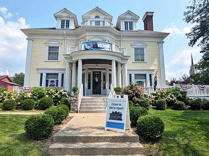 The stately yellow Victorian mansion housing the Midwest Miniatures Museum stands proudly in Grand Haven, welcoming visitors with its grand columns and wrap-around porch.