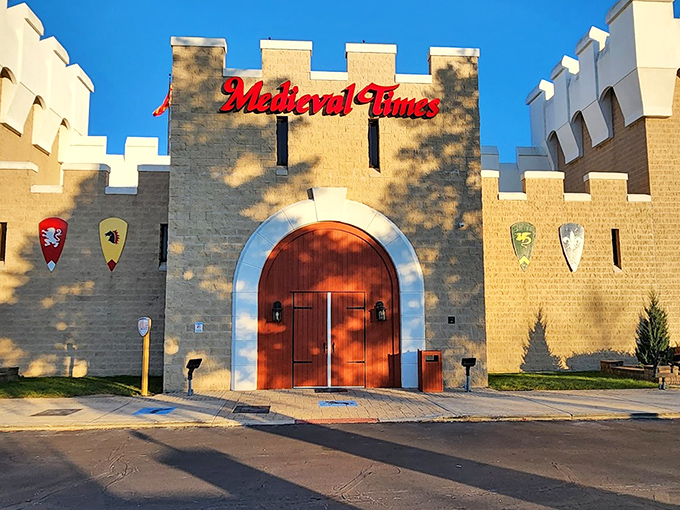 The imposing castle façade of Medieval Times Schaumburg welcomes visitors with its stone walls, red doors, and distinctive medieval architecture.