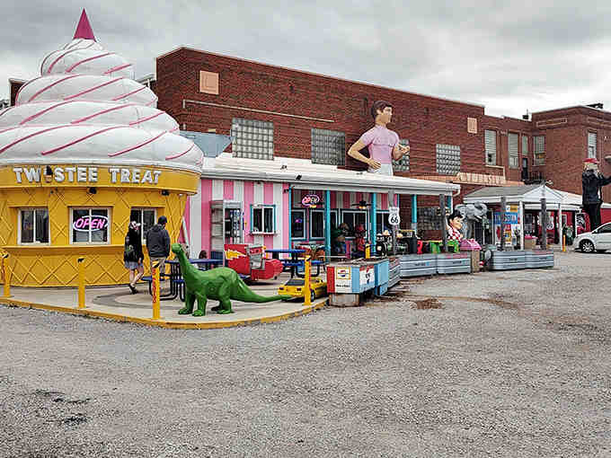 The eye-catching exterior of Twistee Treat Diner beckons travelers with its giant ice cream cone structure and vibrant pink-and-yellow facade – a Route 66 landmark that demands attention.