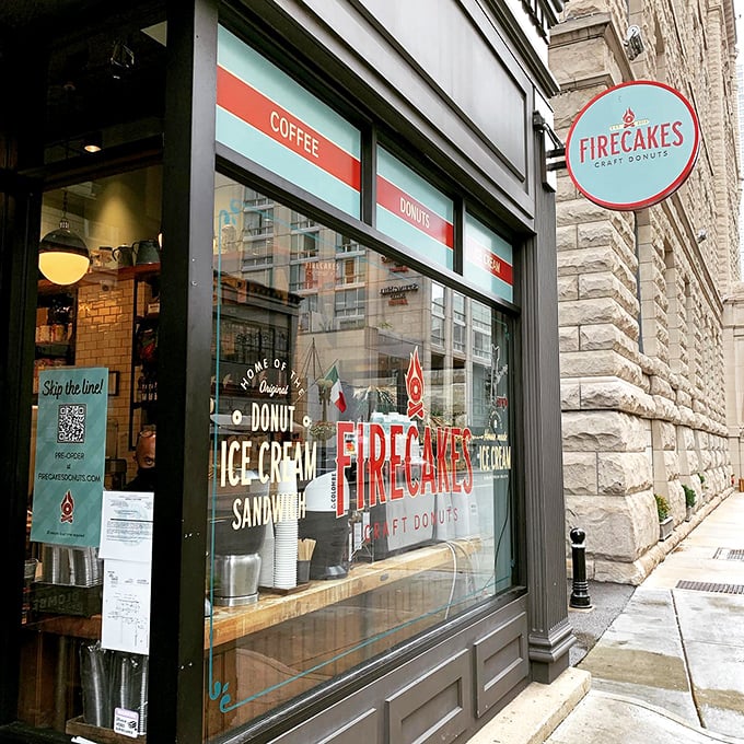 The inviting storefront of Firecakes Donuts beckons from its historic Chicago building, promising sweet treasures within those glass-fronted walls.