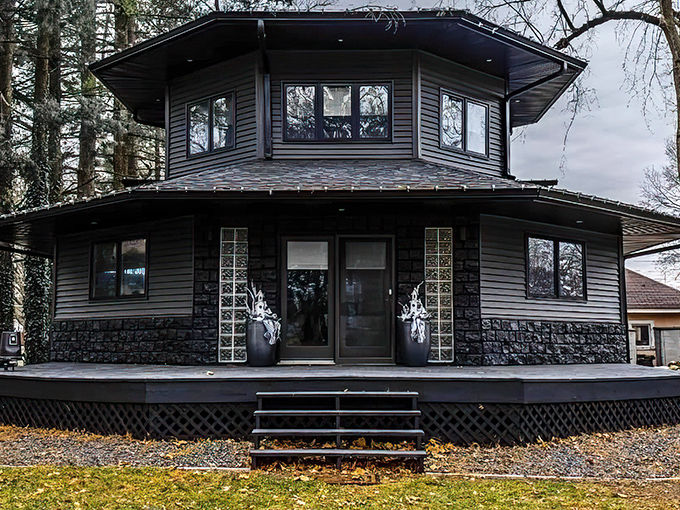 The octagonal black house stands like a modern gothic castle, its dark exterior promising mysteries within the Illinois woods.