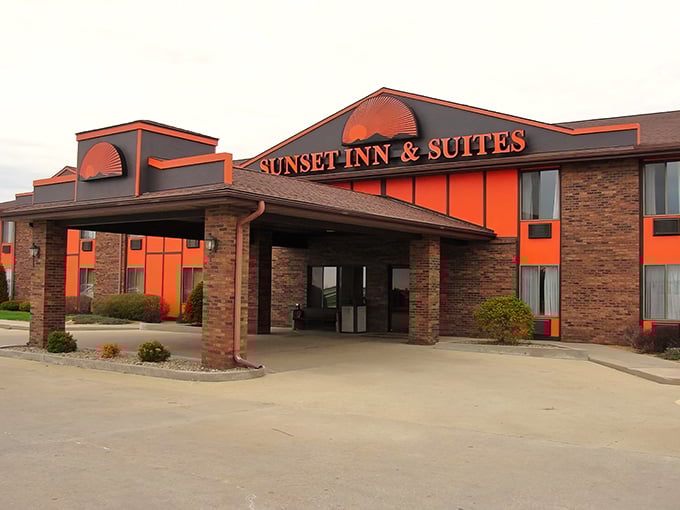 The distinctive orange and brick exterior of Sunset Inn & Suites stands out like a beacon of imagination in Clinton, Illinois.
