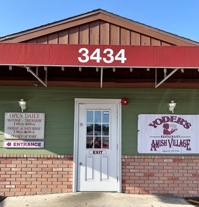 The unassuming green exterior of Yoder's Restaurant hides a world of culinary treasures behind its modest facade and iconic red awning.