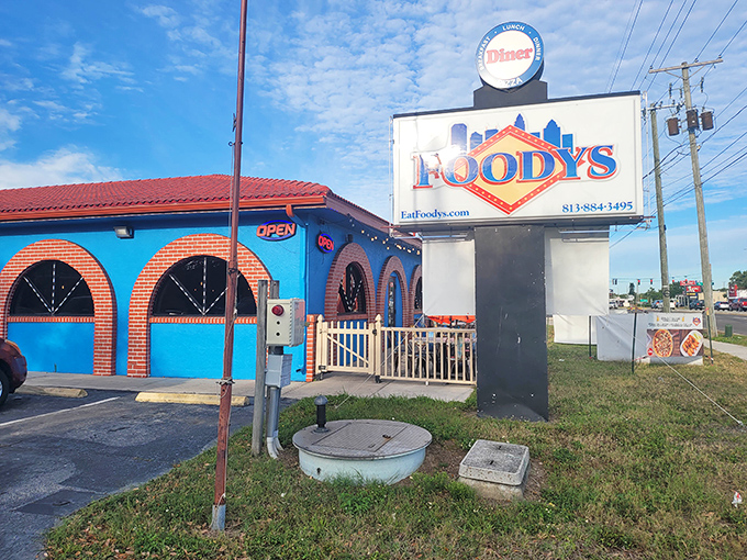 Foodys' vibrant blue exterior with distinctive red roof stands out like a Mediterranean oasis in Tampa's urban landscape.
