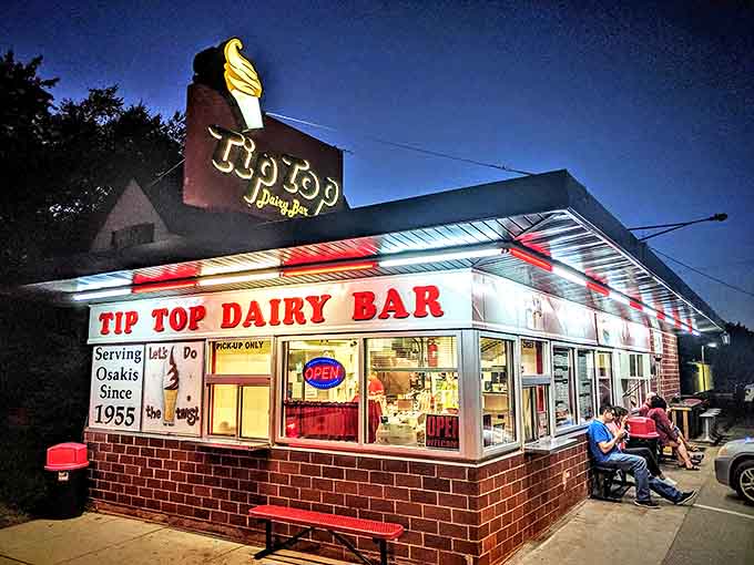 The iconic Tip Top Dairy Bar glows like a beacon in the evening, its vintage sign promising sweet relief from Minnesota summer nights.