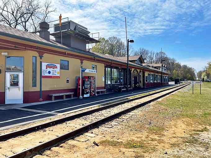 The historic train station exterior gleams in sunshine, its mustard-yellow and burgundy façade promising culinary adventures where passengers once waited for journeys.