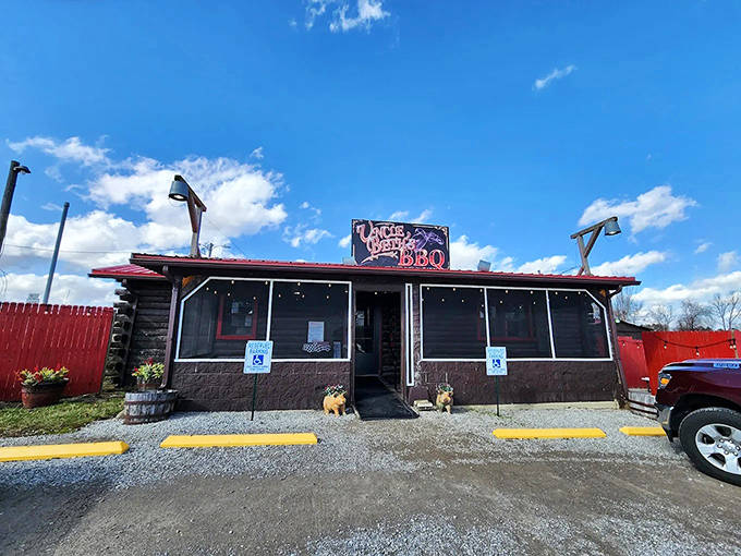 The unassuming log cabin exterior of Uncle Beth's BBQ stands like a beacon of hope for hungry travelers, its red roof a promise of delicious things to come.