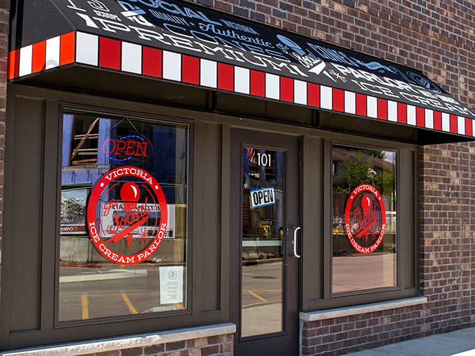 The classic red-and-white striped awning beckons like a sweet siren call, promising frozen treasures within this brick-fronted ice cream sanctuary.