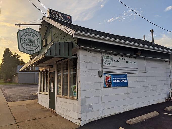 Kennedy's Bar-B-Que exterior stands as a humble time capsule, its weathered white siding and vintage sign promising authentic flavors that transcend decades.