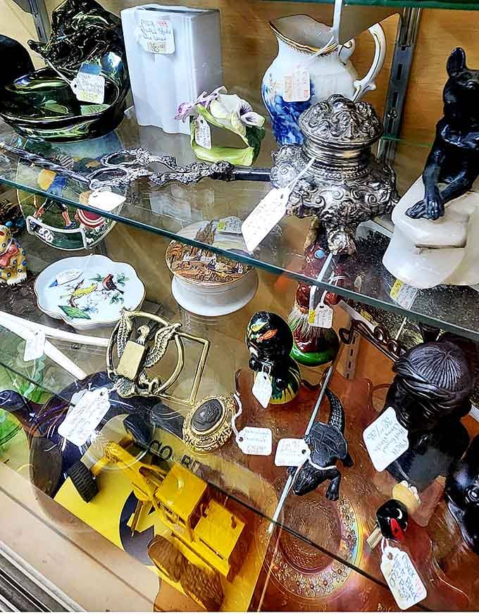 Delicate figurines and silver treasures gleam behind glass, patiently waiting for their next caretaker to continue their story.