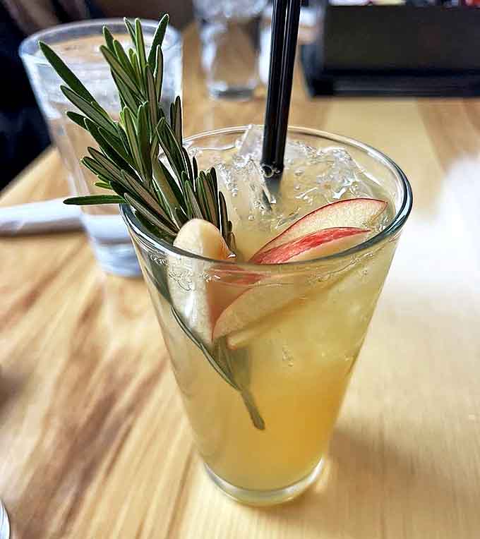 The apple ginger refresher, garnished with fresh rosemary and apple slices, offers a sophisticated non-alcoholic option that's as pretty as it is refreshing.