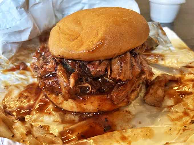 A monument to excess, this pulled pork sandwich threatens to collapse under its own delicious weight, a risk worth taking.