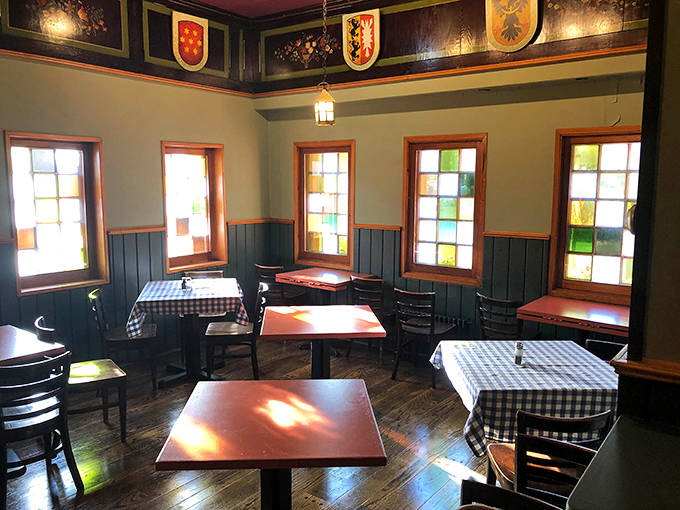 Vintage stained glass catches the light while diners settle into conversations that flow as freely as the German beer.