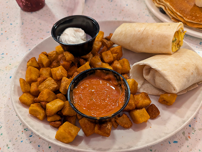 Breakfast Burritos: Handheld happiness wrapped in a tortilla, surrounded by crispy home fries and accompanied by dipping sauces for customizable flavor adventures.