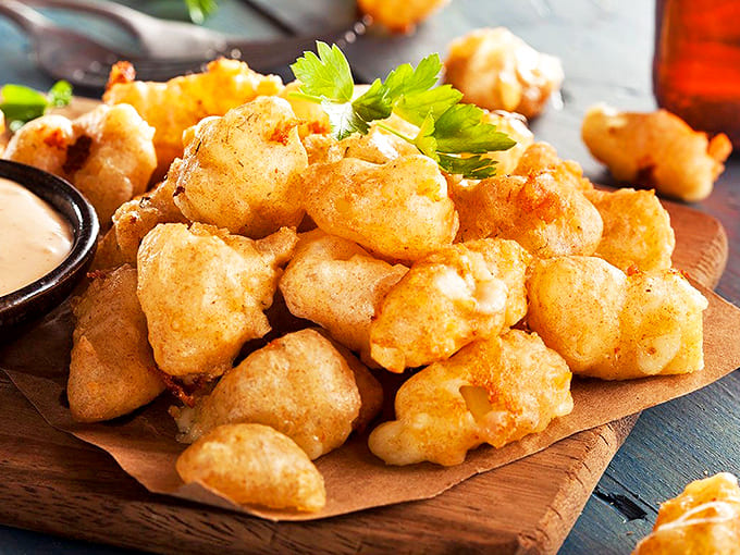 Minnesota's dairy legacy gets the royal treatment with these golden cheese curds &ndash; crispy outside, stretchy inside, and completely irresistible all around.