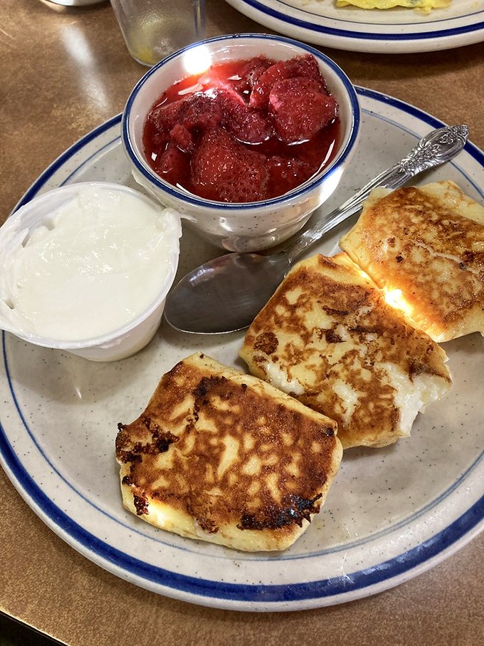 Sweet cheese blintzes served with fresh strawberries and sour cream &ndash; a delightful Eastern European tradition that found a happy home in Florida.