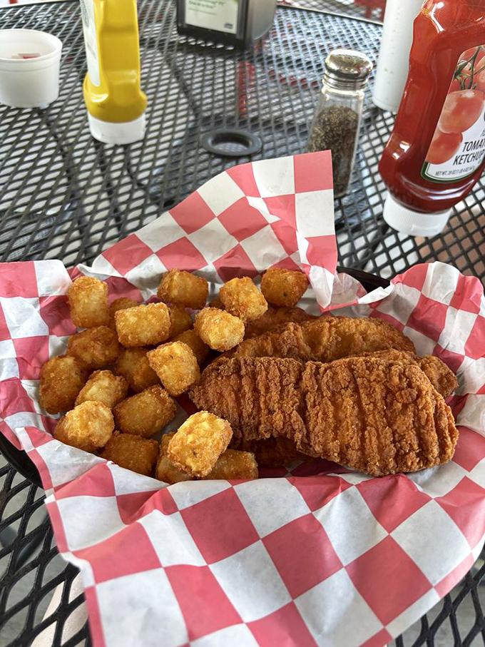 Crispy chicken strips and golden tots on a red-checkered basket &ndash; proof that sometimes the simplest meals bring the most satisfaction.