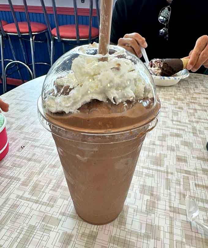 This isn't just a milkshake; it's a tower of indulgence topped with whipped cream that defies gravity and common sense.