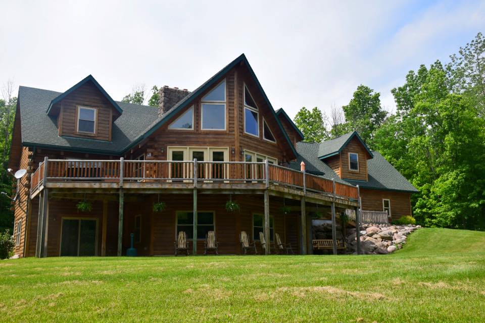 The wrap-around deck extends living space outdoors, offering multiple vantage points to appreciate the surrounding forest from comfortable seating areas.