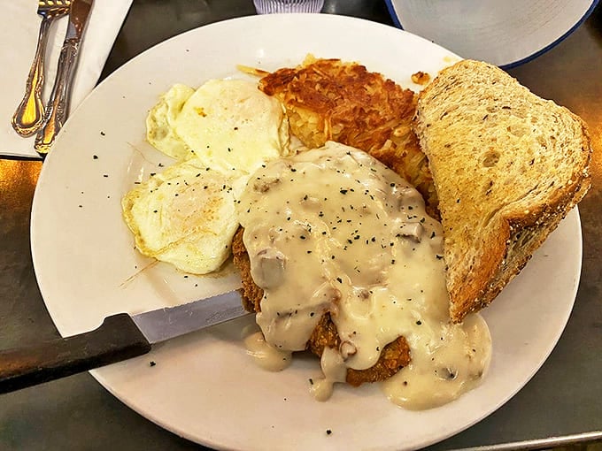 Country Fried Steak Comfort food perfection &ndash; crispy breaded steak swimming in peppery gravy alongside golden hash browns and perfectly cooked eggs.
