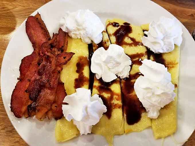 These crepes with whipped cream dollops and bacon on the side prove that breakfast can be both sophisticated and deeply comforting.
