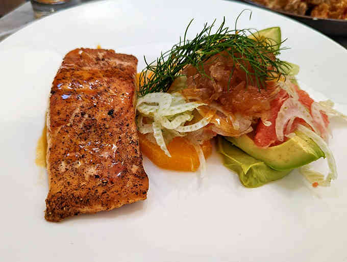Perfectly seared salmon meets vibrant accompaniments in a dish that showcases the kitchen's "simple isn't easy" philosophy.