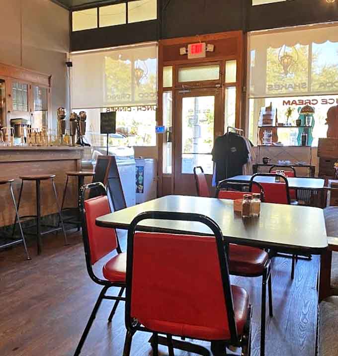 Red chairs against wooden floors create the perfect backdrop for conversations that matter &ndash; no Wi-Fi password required, just genuine human connection.
