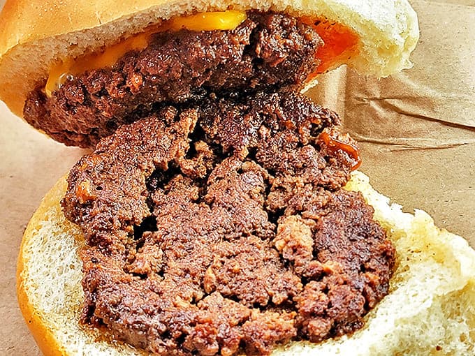 A cross-section reveals the beautiful simplicity of Crabill's craft &ndash; seasoned beef, melty cheese, and a soft bun creating burger perfection.