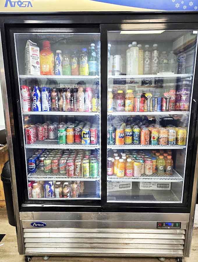 The refrigerated rainbow of beverages stands ready to wash down your donut indulgence &ndash; because proper hydration matters, even during pastry adventures.