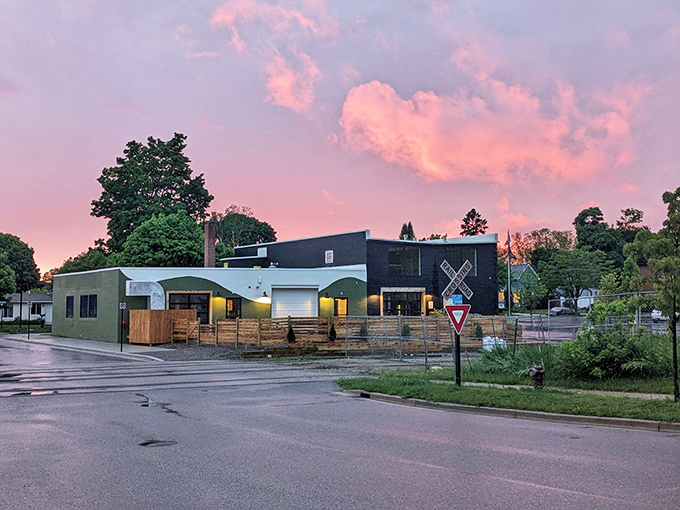 Sunset paints the sky over a modern establishment—where craft beverages and local cuisine await after a day of exploration.