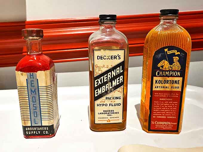Vintage embalming fluids with their original labels offer a glimpse into the practical chemistry behind funeral preparation through the decades.